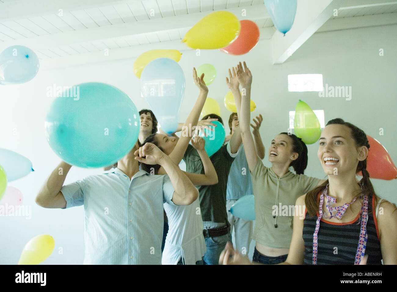 Group of young friends hitting balloons floating in the air Stock Photo ...
