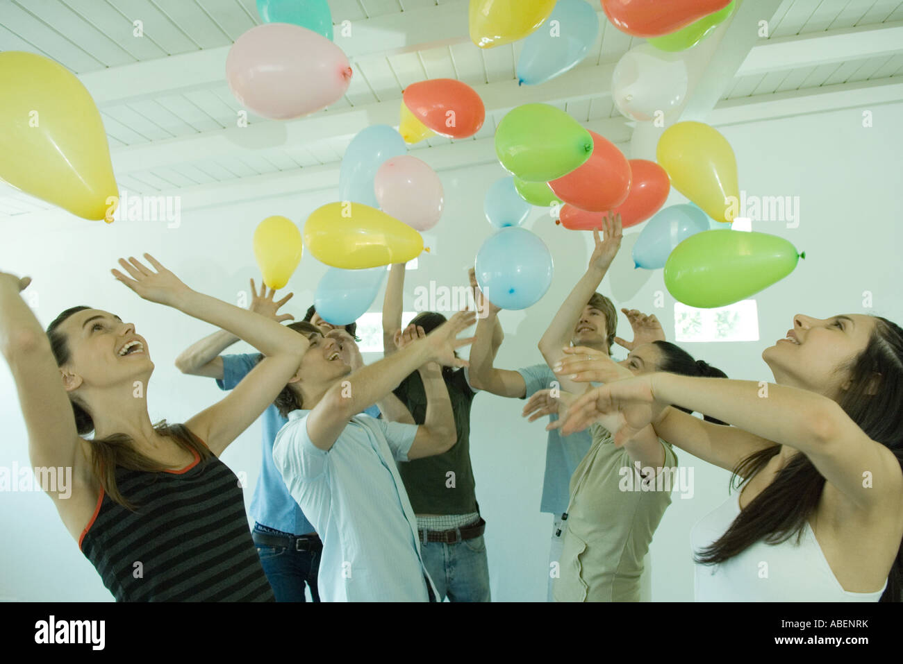 Group of young friends hitting balloons floating in the air Stock Photo ...