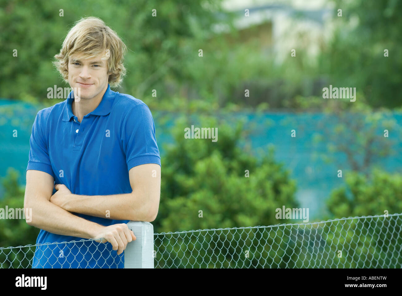 Young man on chain link fence hi-res stock photography and images - Alamy