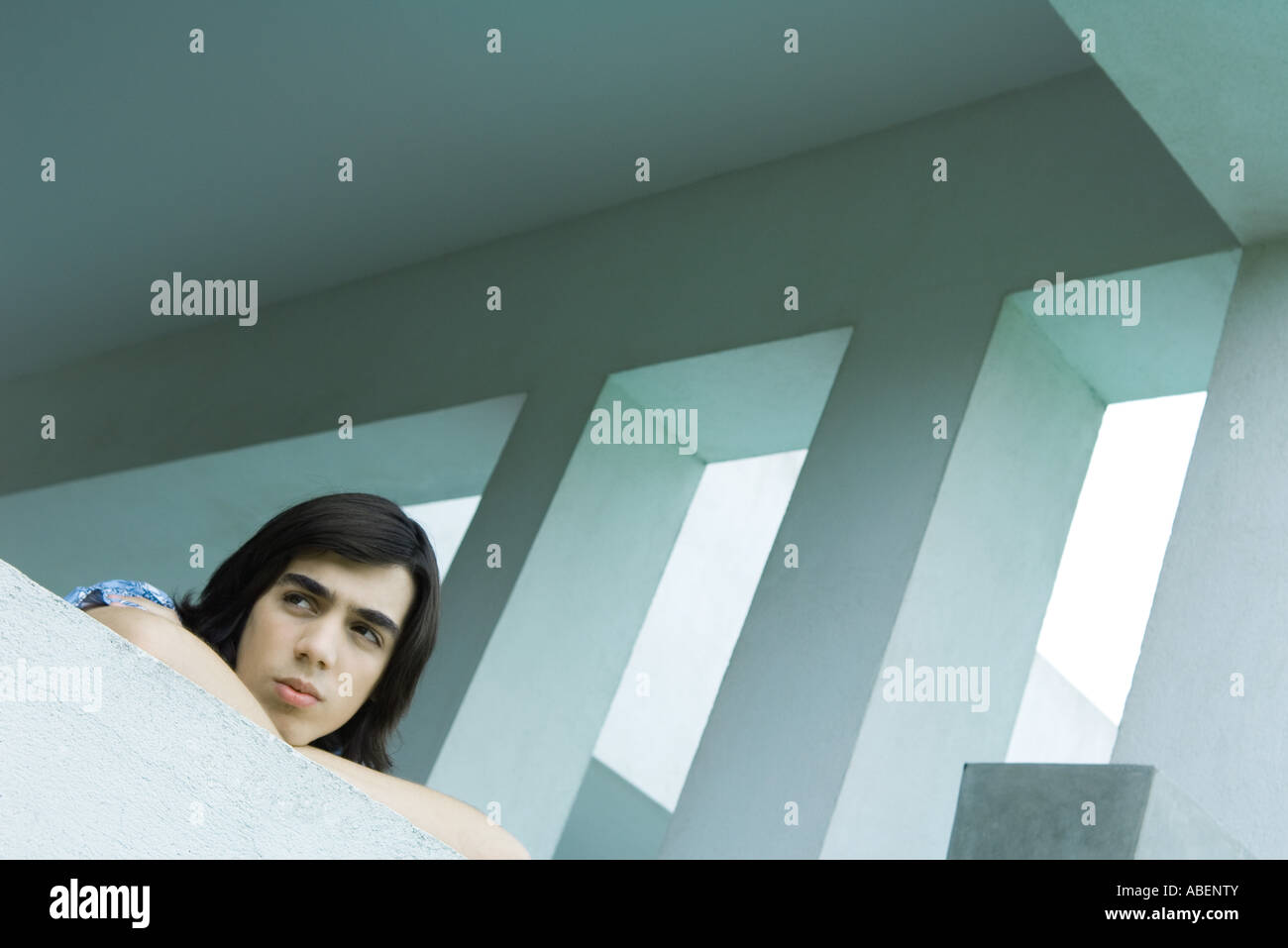 Teen boy leaning on balcony Stock Photo - Alamy