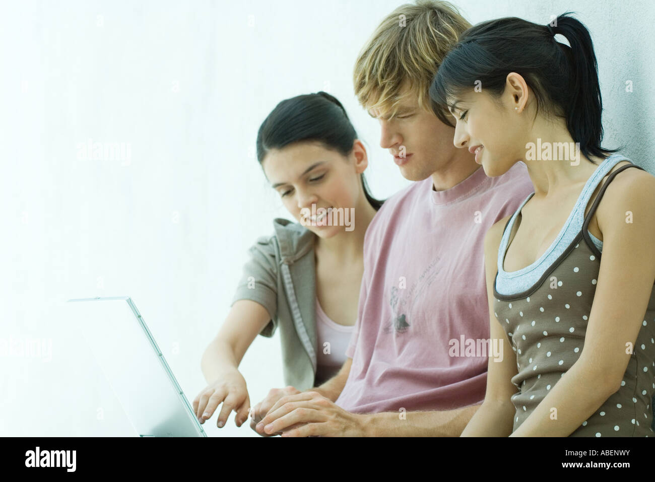 Young friends using laptop together Stock Photo - Alamy