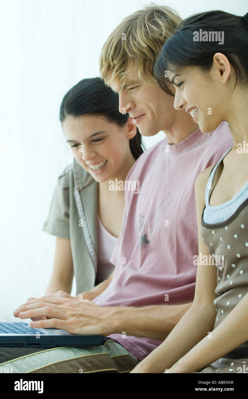 Young friends using laptop together Stock Photo - Alamy