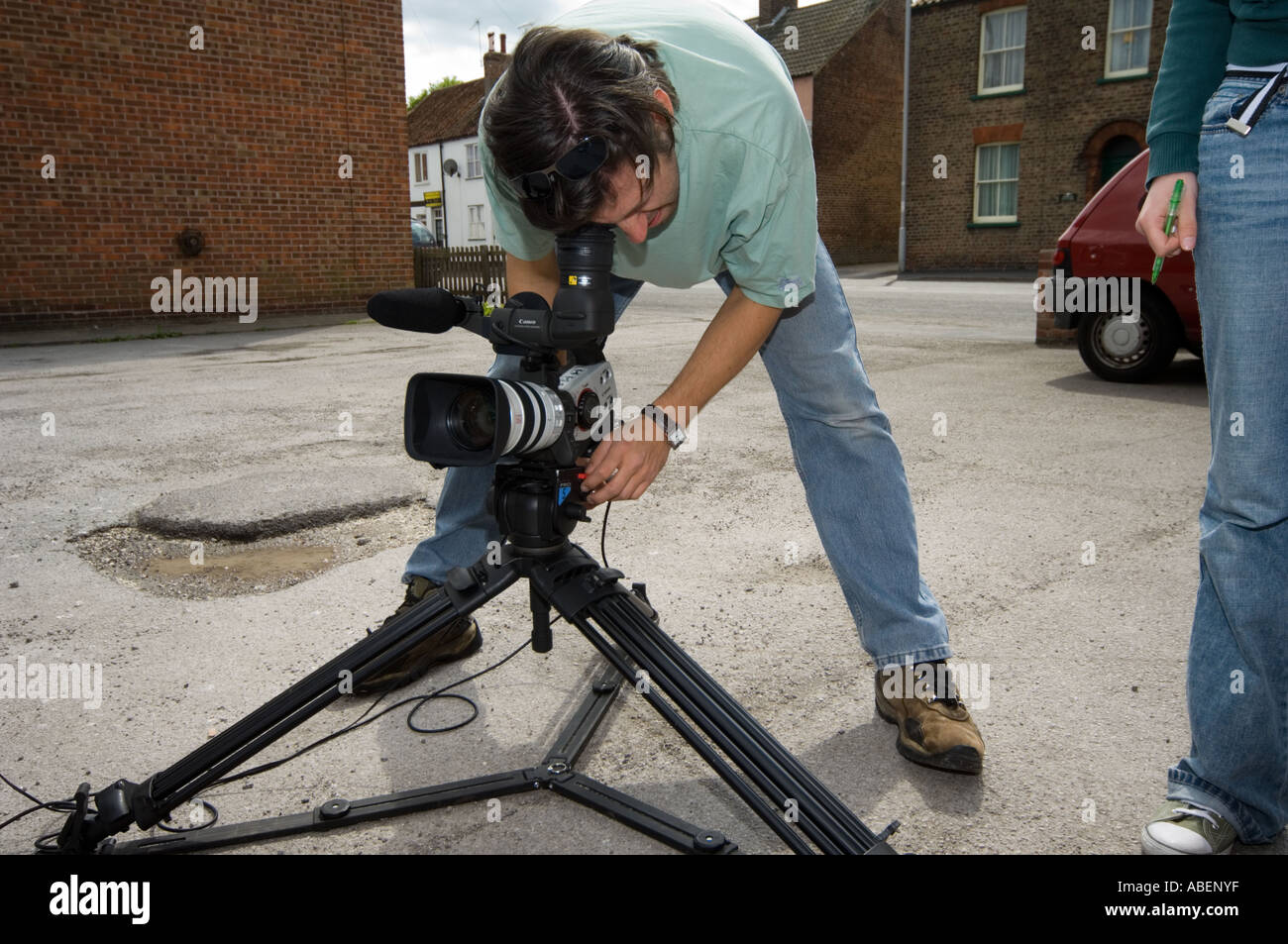 Film Cameraman looking through eyepiece on camera Stock Photo - Alamy
