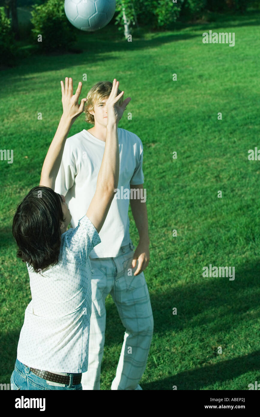 Young male friends playing with soccer ball on lawn Stock Photo - Alamy