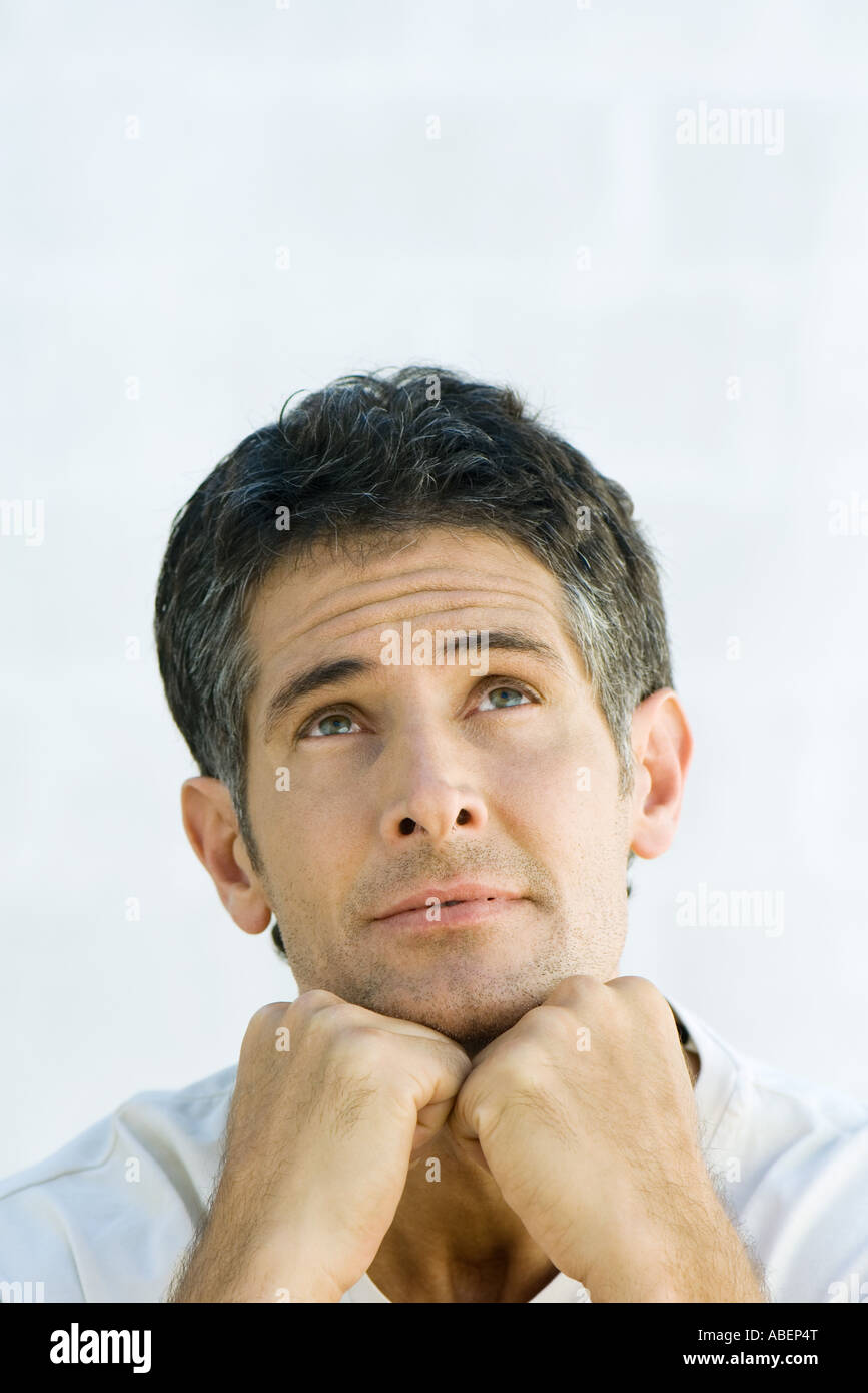 Man, hands under chin, looking up, portrait Stock Photo - Alamy