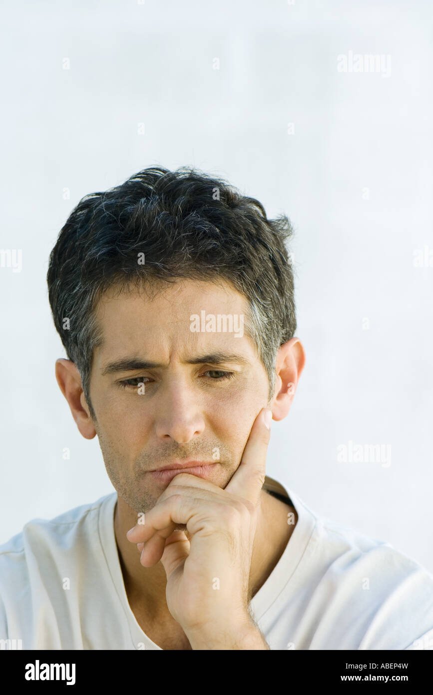 Man, holding head, looking down, portrait Stock Photo - Alamy