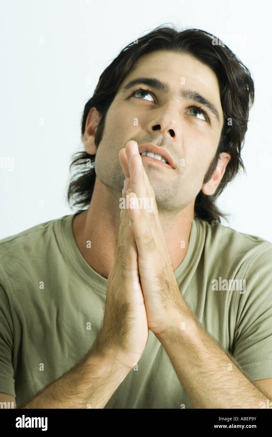 Man hands together, looking up, portrait Stock Photo - Alamy