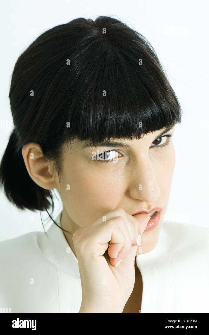 Woman biting thumb, portrait Stock Photo - Alamy