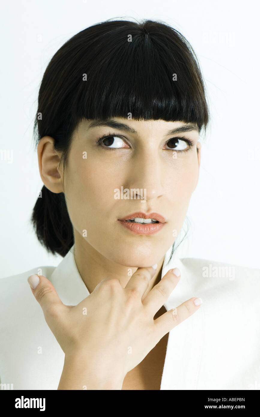 Woman holding hand under chin, looking away, portrait Stock Photo - Alamy