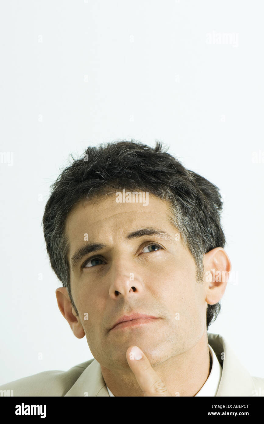Man, finger on chin, looking up, portrait Stock Photo - Alamy