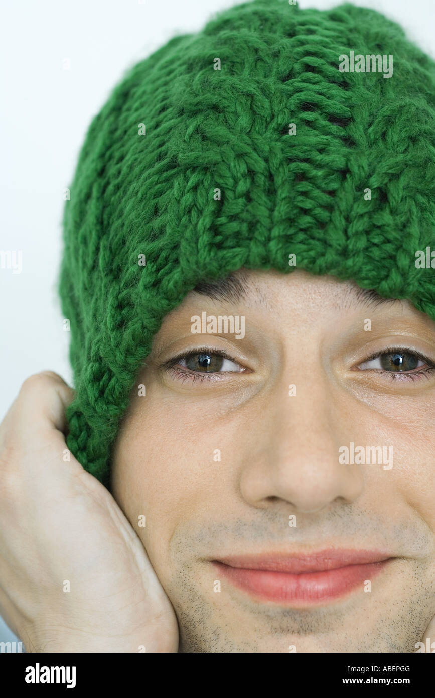 Young man pulling down knit hat over ears, portrait, close-up Stock ...