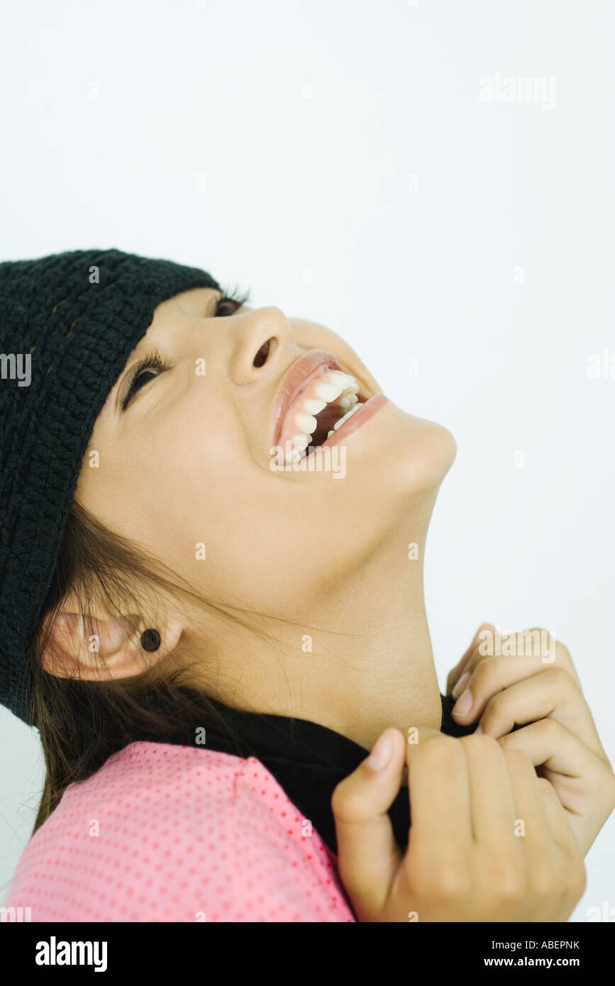 Teen girl wearing knit hat, head back, laughing, portrait Stock Photo ...