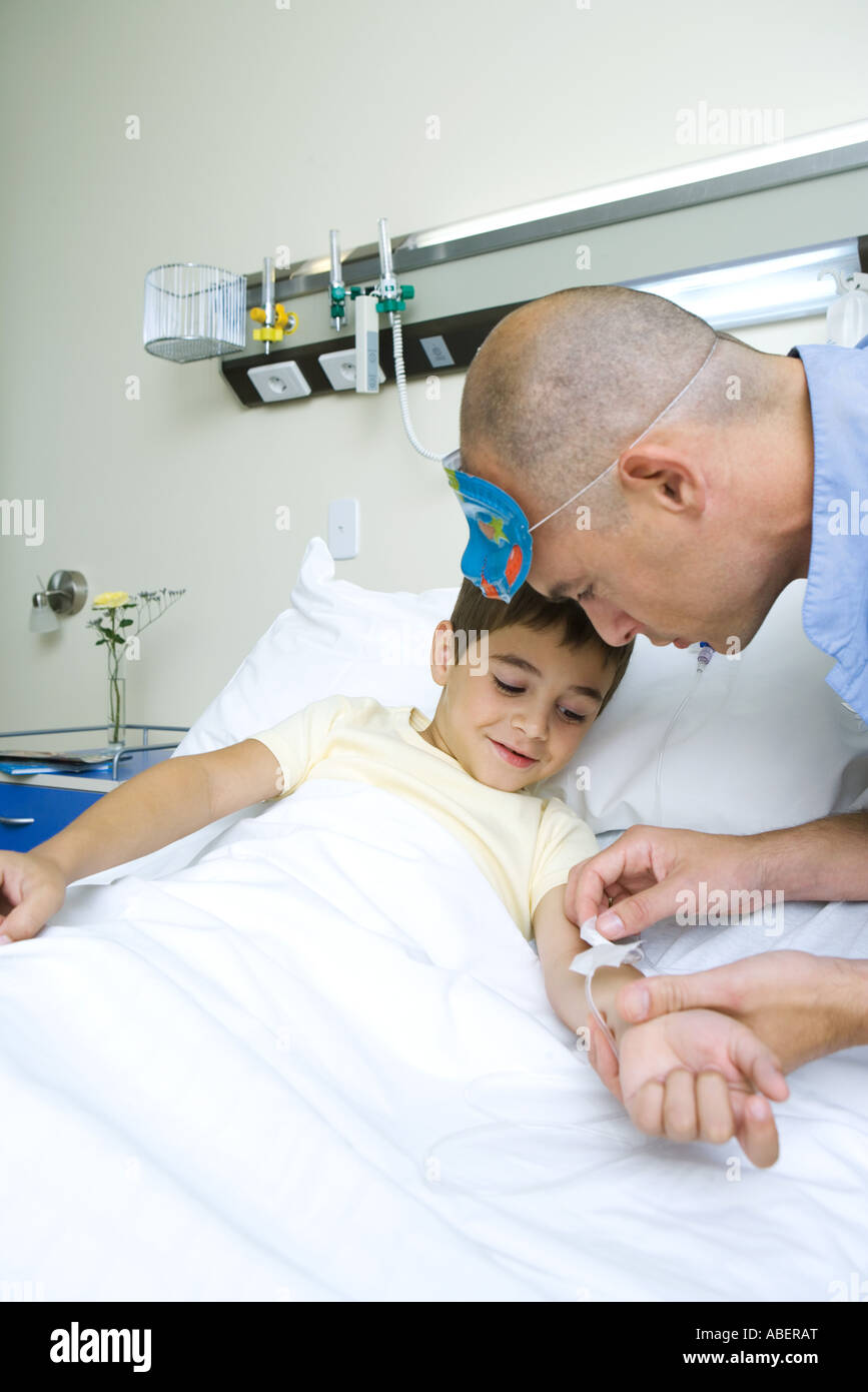 Boy lying in hospital bed, nurse adjusting IV Stock Photo - Alamy