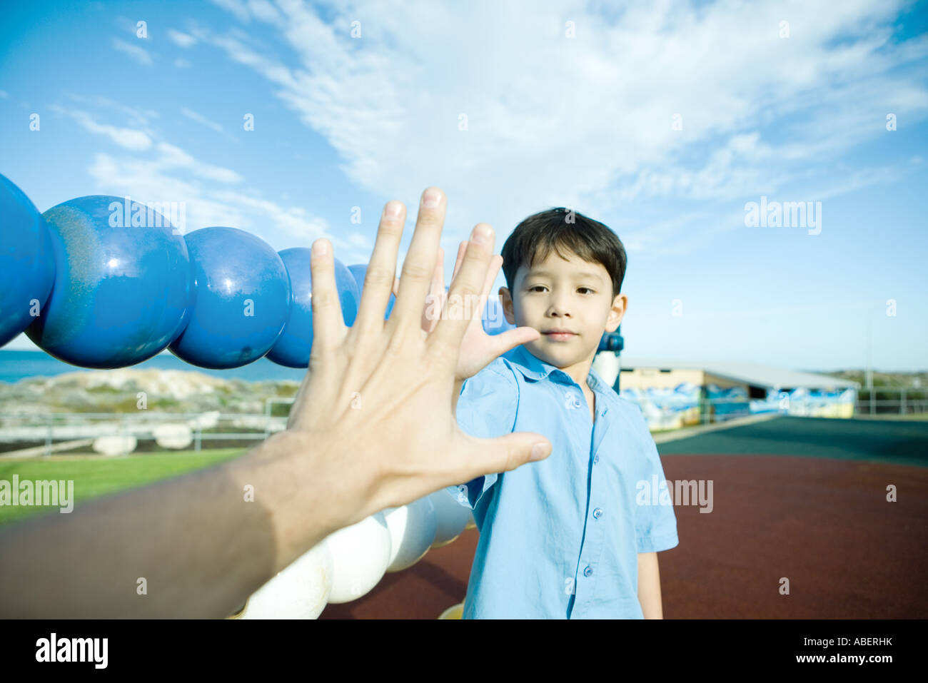 Boy on playground, holding out hand to adult hand Stock Photo - Alamy