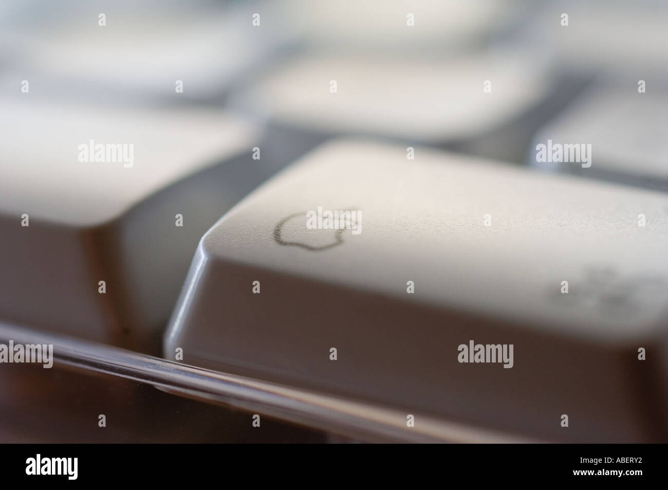 Apple Mac Keyboard on a wooden desktop, showing the Apple Logo in ...