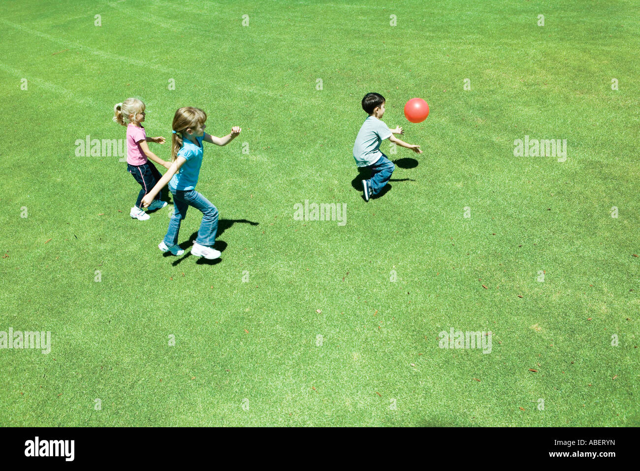 Children playing ball on grass Stock Photo - Alamy
