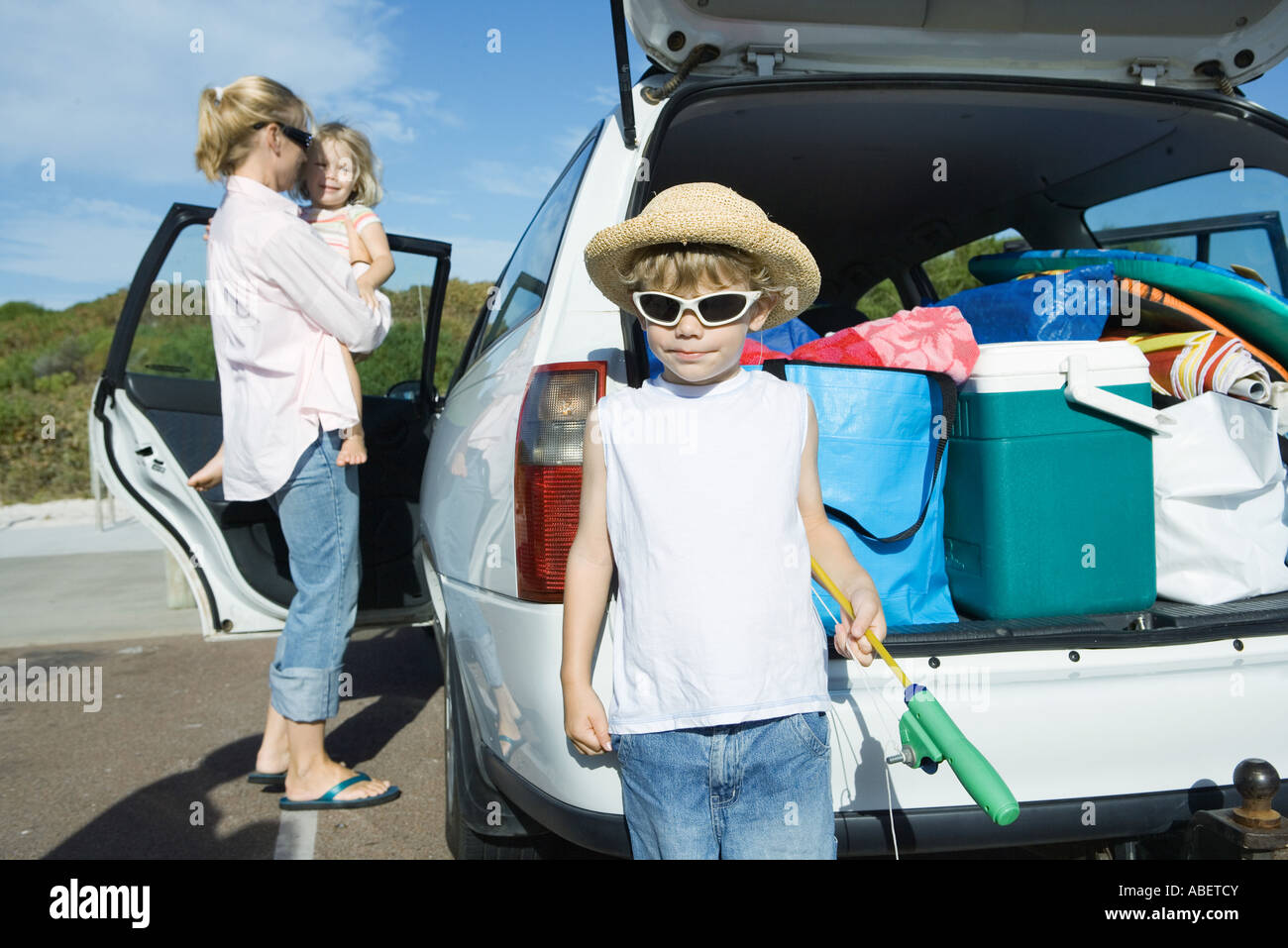 Boy standing in front of loaded car trunk Stock Photo - Alamy