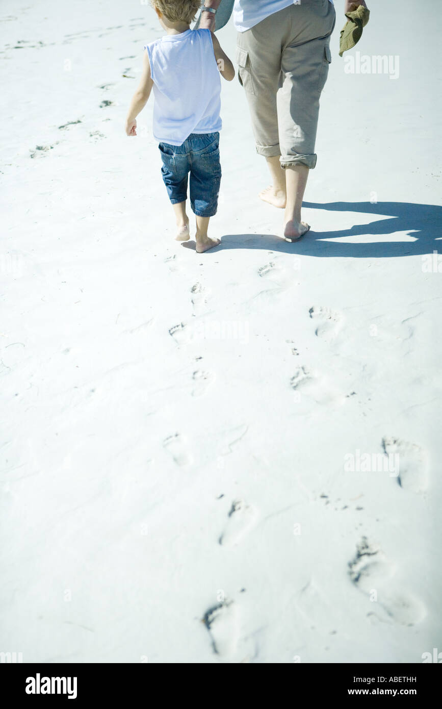 Child and adult walking on sand, low section Stock Photo - Alamy