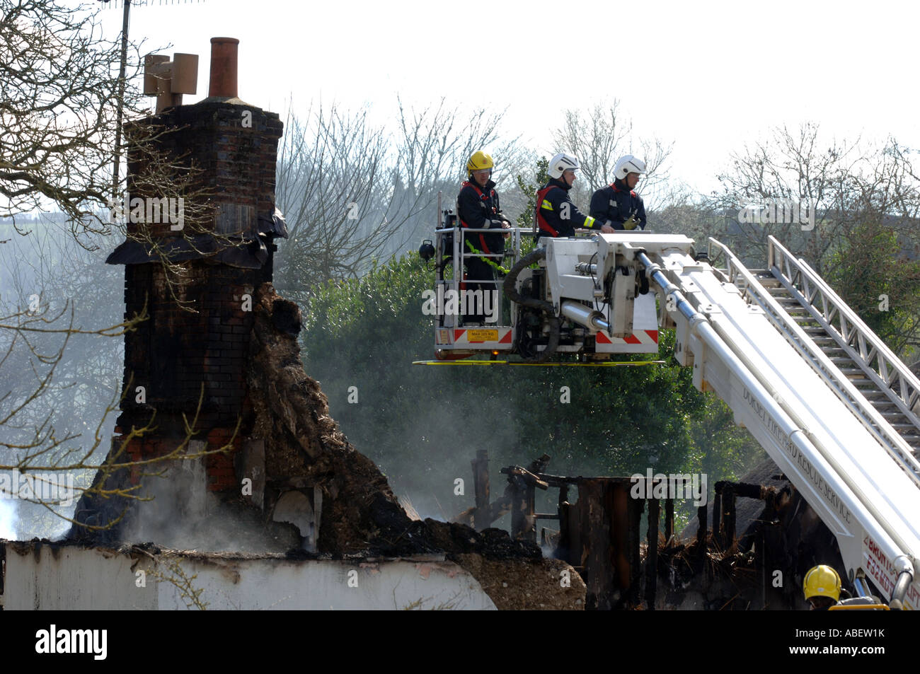 Firefighters at a burnt out cottage in Piddlehinton, Dorset, Britain ...