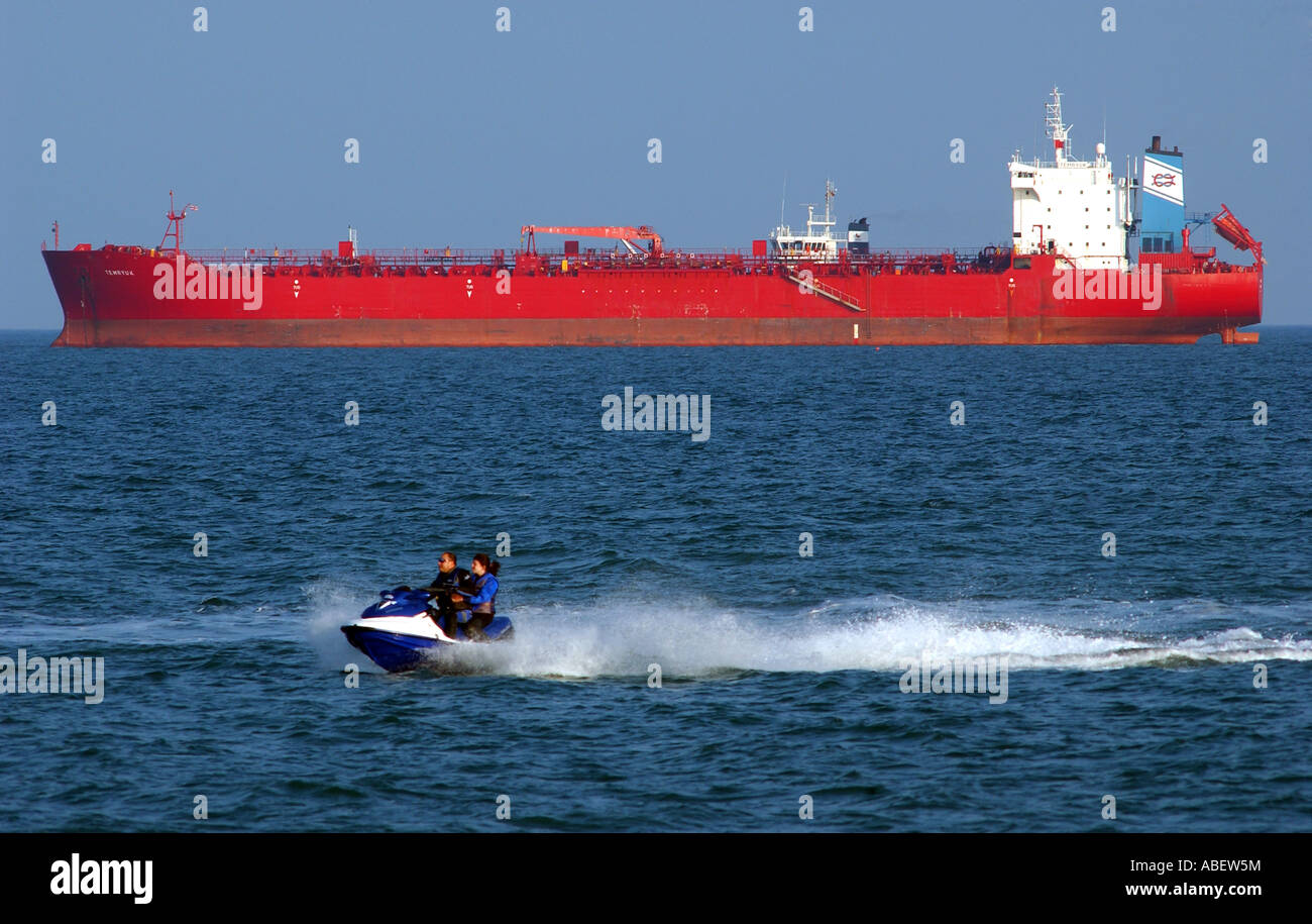 Jet ski passing an tanker ship Stock Photo - Alamy