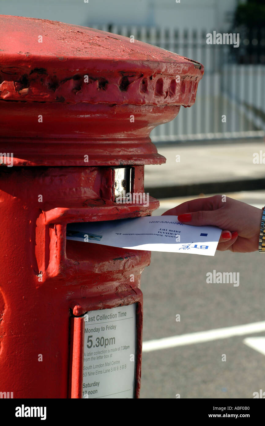 posting a letter into red postbox London England United Kingdom UK ...