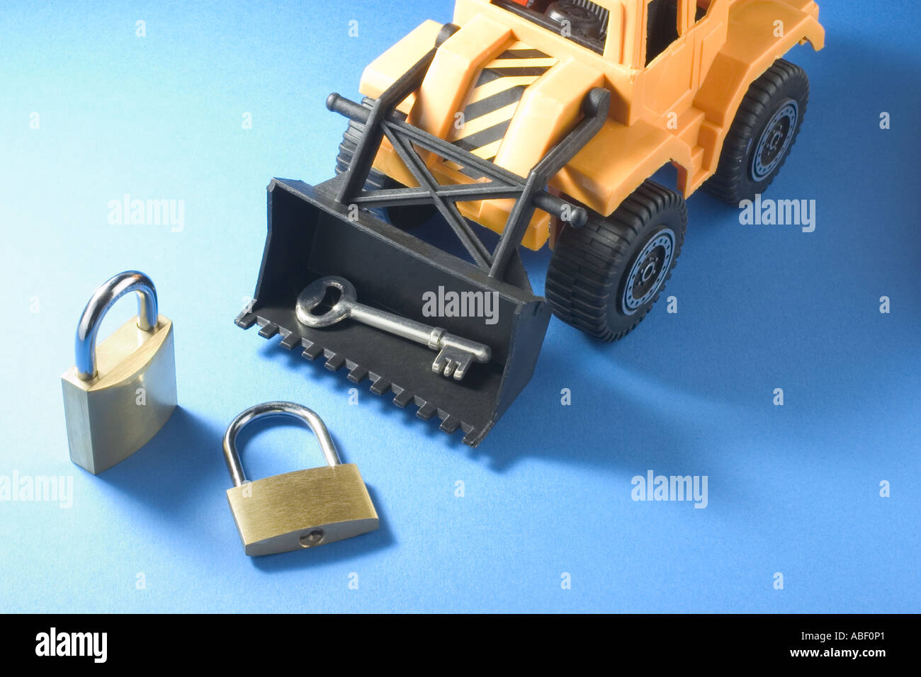 Toy Earthmover with Key and Padlocks Stock Photo - Alamy