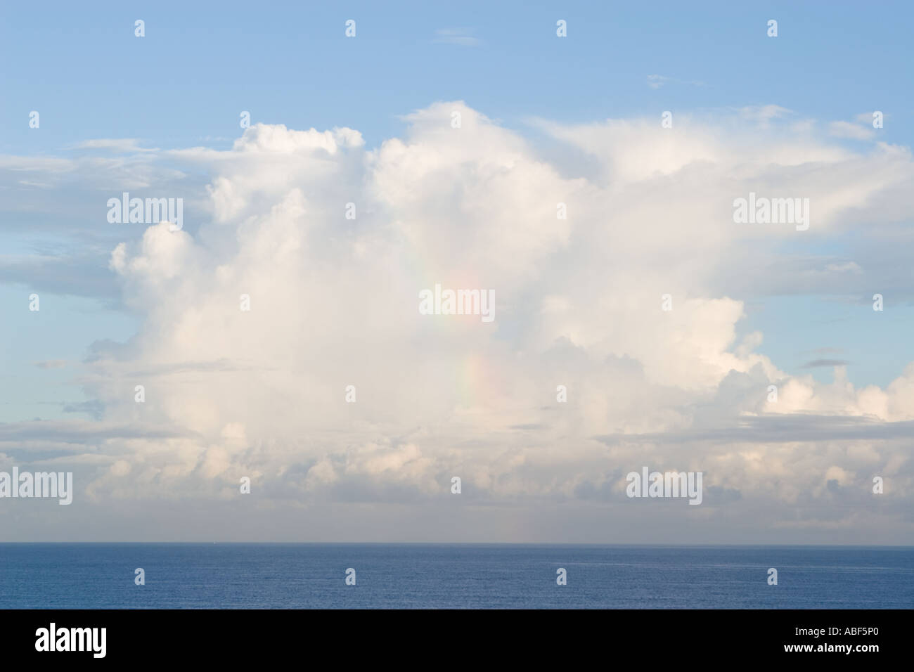 A rainbow in cumulus clouds forming over the Caribbean Sea near ...