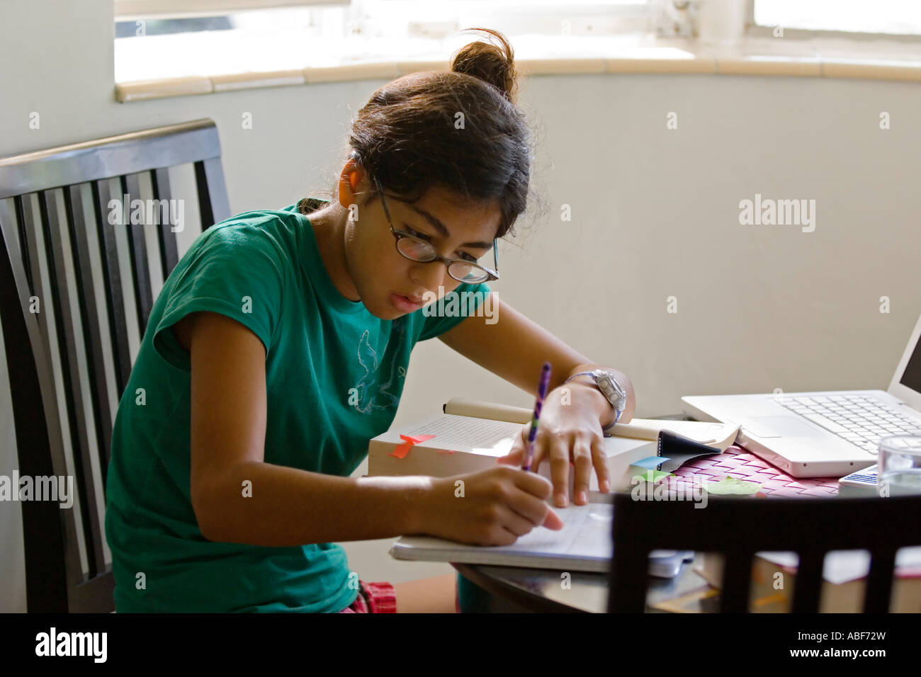 Teenage Hispanic girl does homework at kitchen table Miami, Florida ...