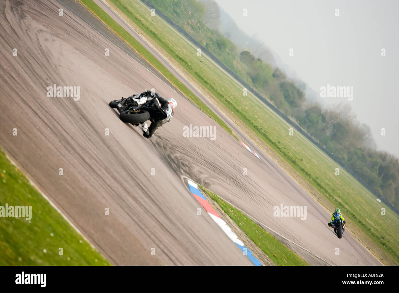 2 racing motorbikes riders lean through bends in superbike competition ...