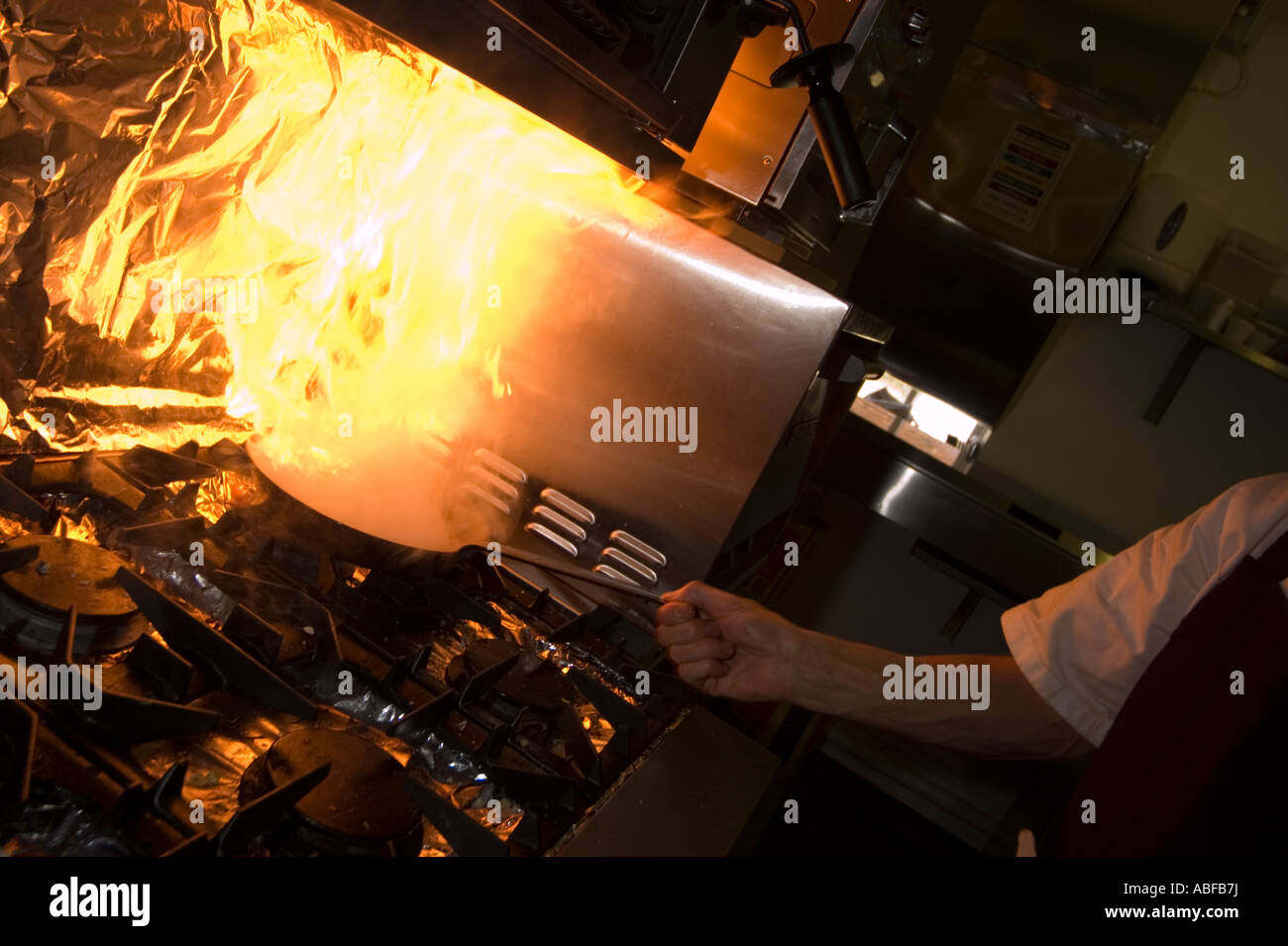 a chef cooking up a large flame in the kitchen cooking something this ...