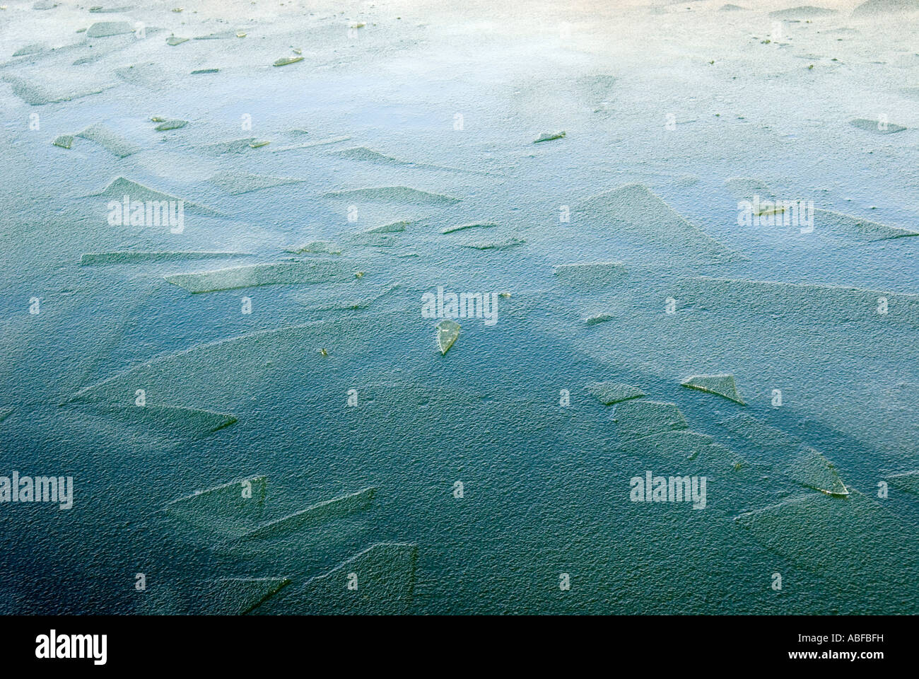 frozen sheets of ice on a canal near dudley port in the uk with a blue ...