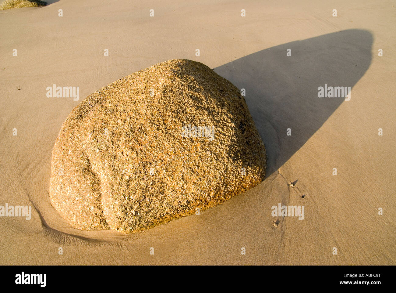 Simple Stone with Shadow on Beach Stock Photo - Alamy