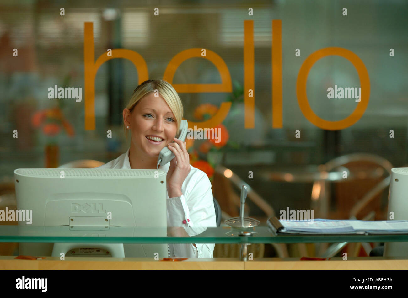 a receptionist answering the telephone and smiling Stock Photo - Alamy