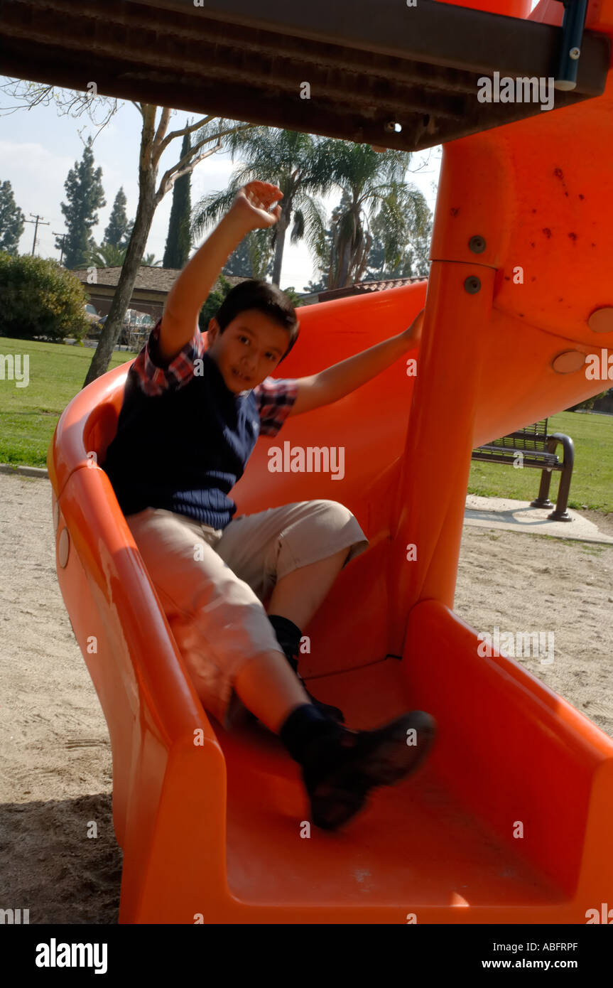 Young boy sliding down slider Stock Photo - Alamy