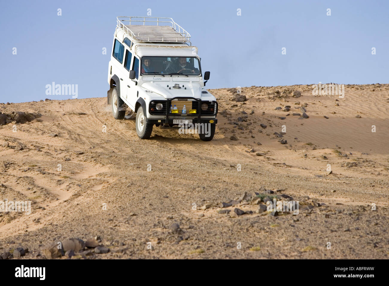 Land Rover Defender four wheel drive vehicle on piste desert sand dune ...