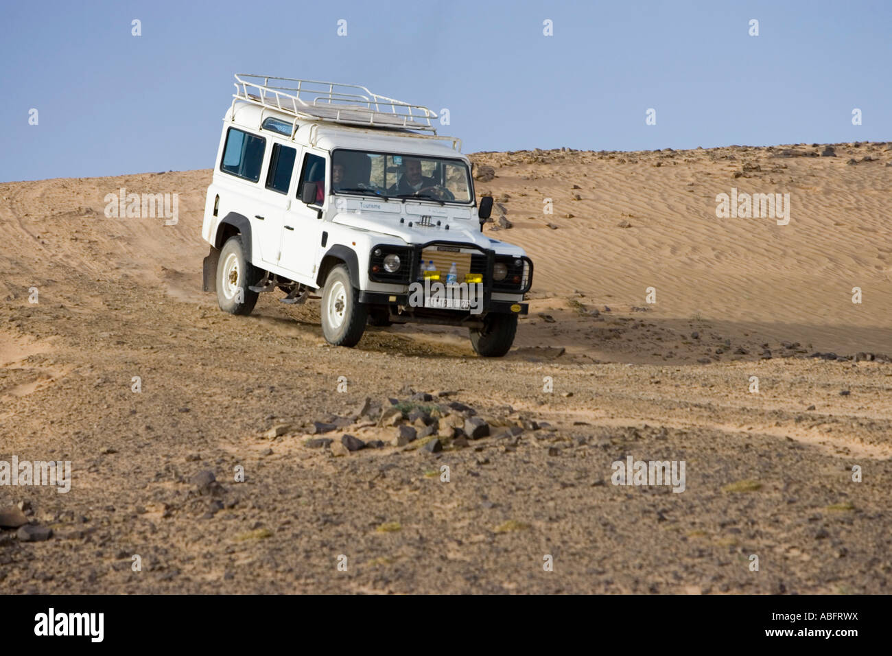 Land Rover Defender four wheel drive vehicle on piste desert sand dune ...