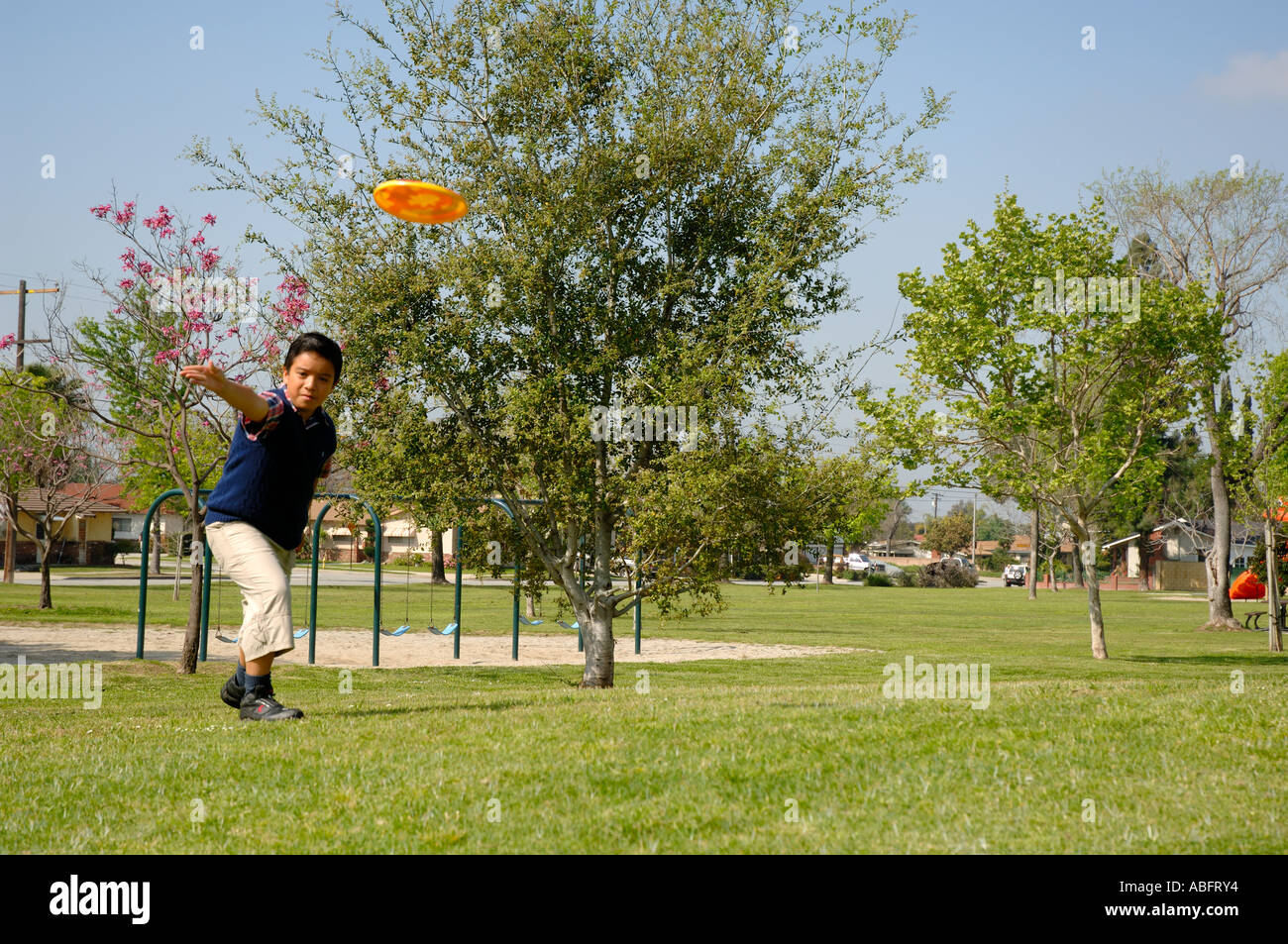 Boy throwing frisbee in park Stock Photo - Alamy