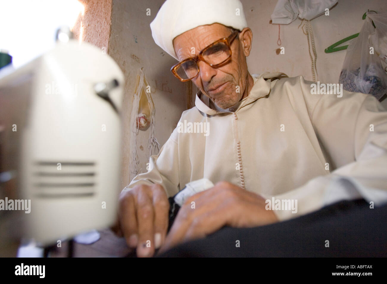 Berber tailor lines up fabric to sew Nekob Morocco Stock Photo - Alamy