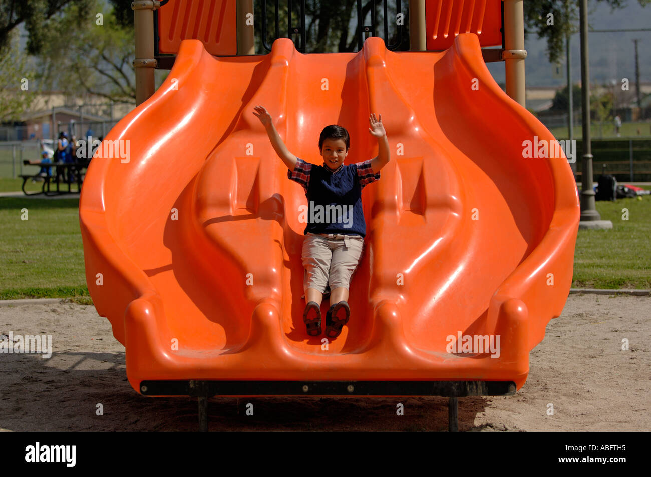 Boy sliding down slider Stock Photo - Alamy