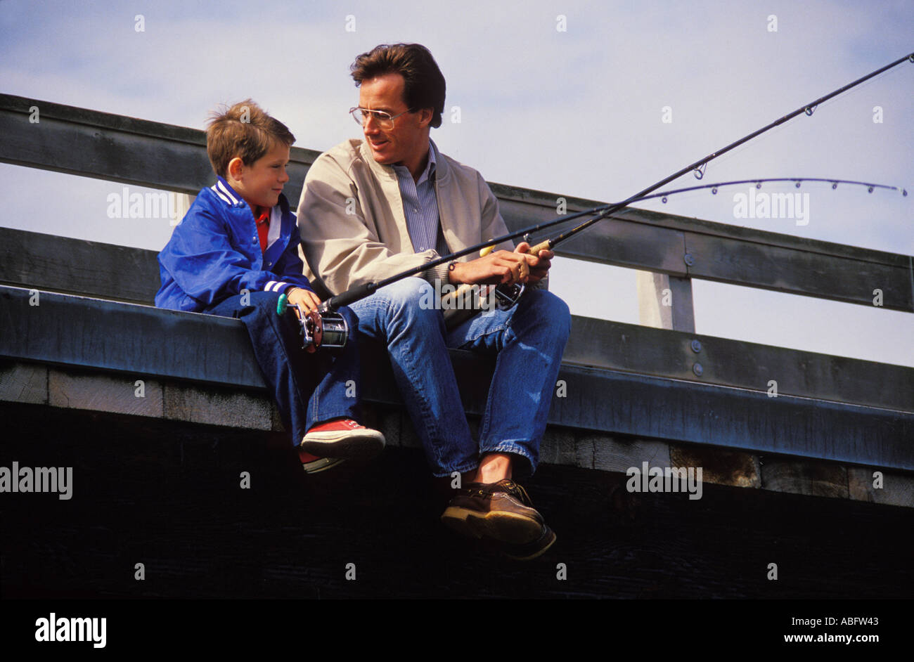 A father and his nine year old son fish from a pier Stock Photo - Alamy