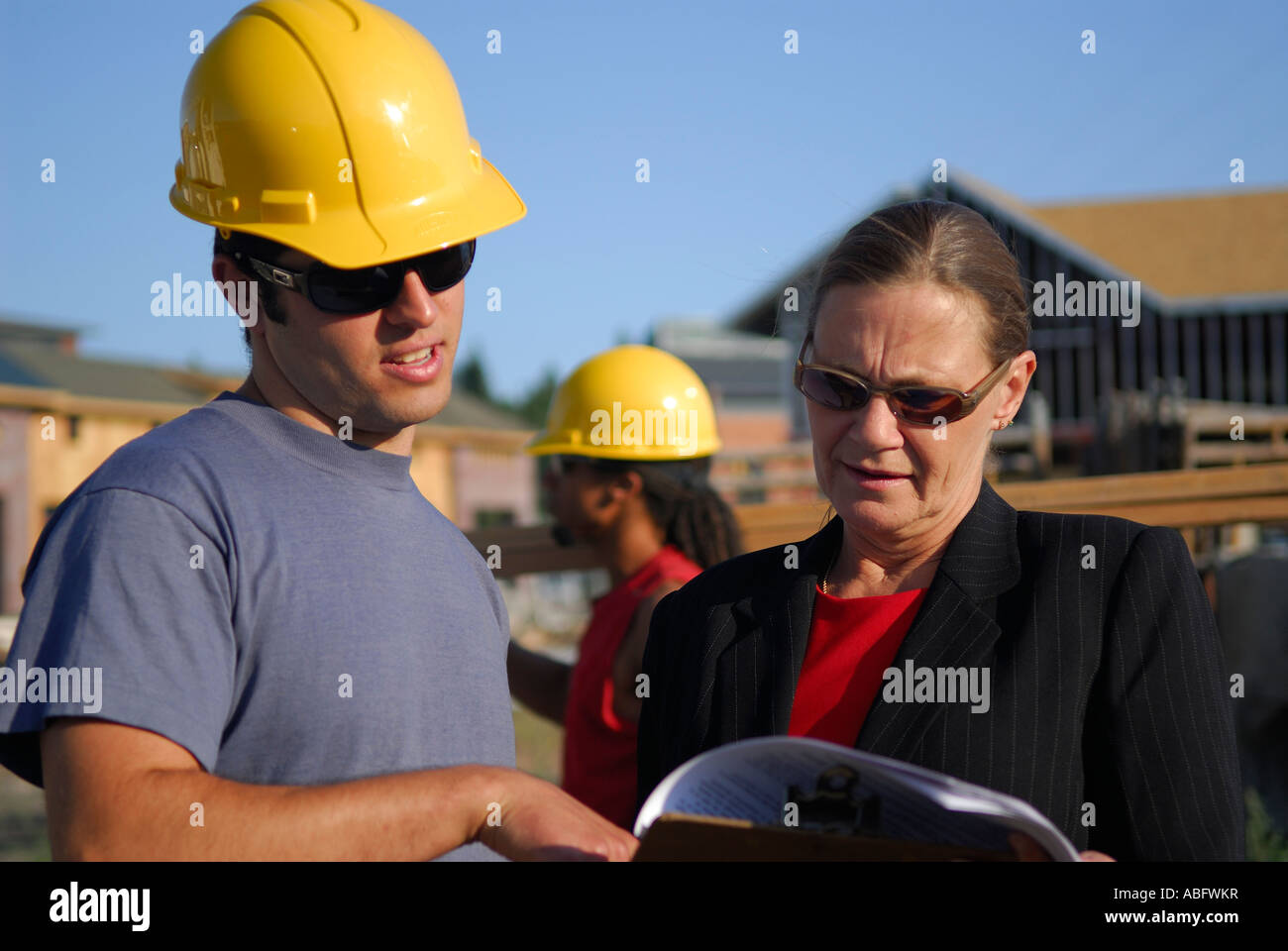 Contractor foreman in hard hat explaining progress to the female ...