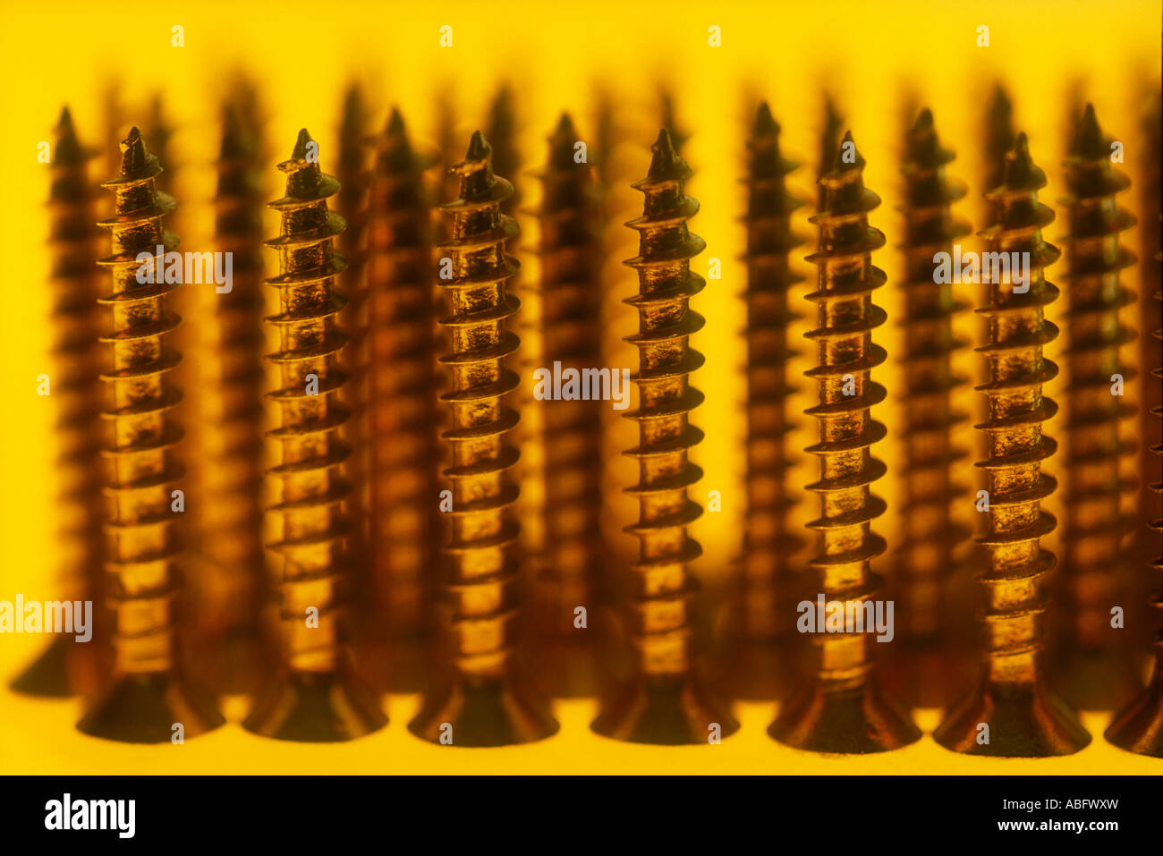 STACK OF THREADED SCREWS ON YELLOW BACKGROUND Stock Photo - Alamy