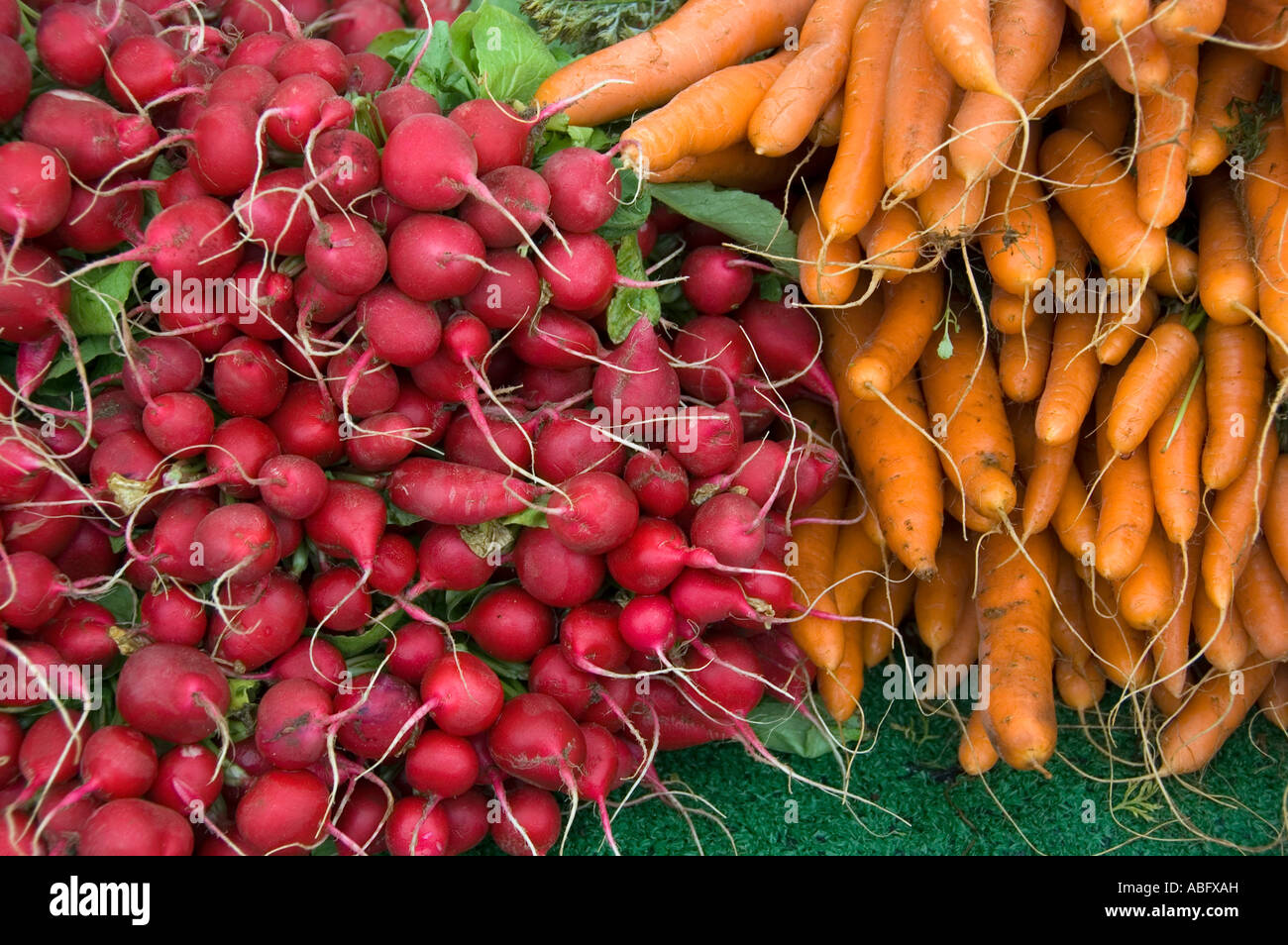 Bunches of root crop radish and carrots for sale Stock Photo - Alamy