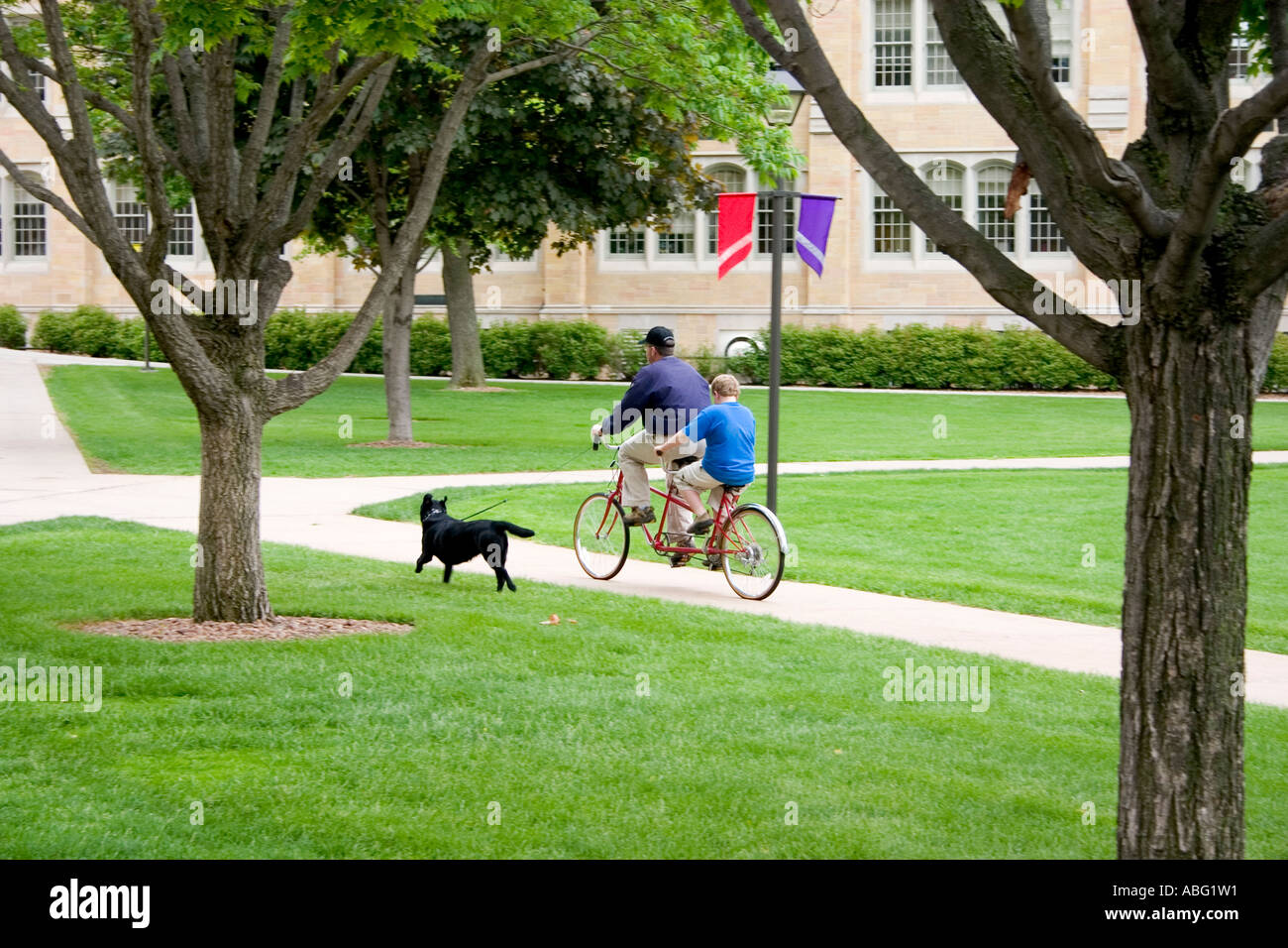 Father and son peddling bicycle past the John R. Roach Center on St ...