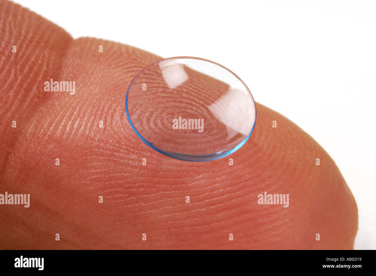 MEDICAL OPTICS lenses on finger tip fingertip Stock Photo - Alamy