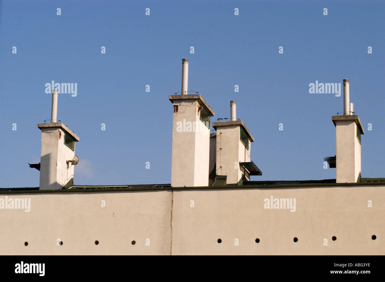 Rooftops and chimneys of modern guarded apartment houses with blue sky ...