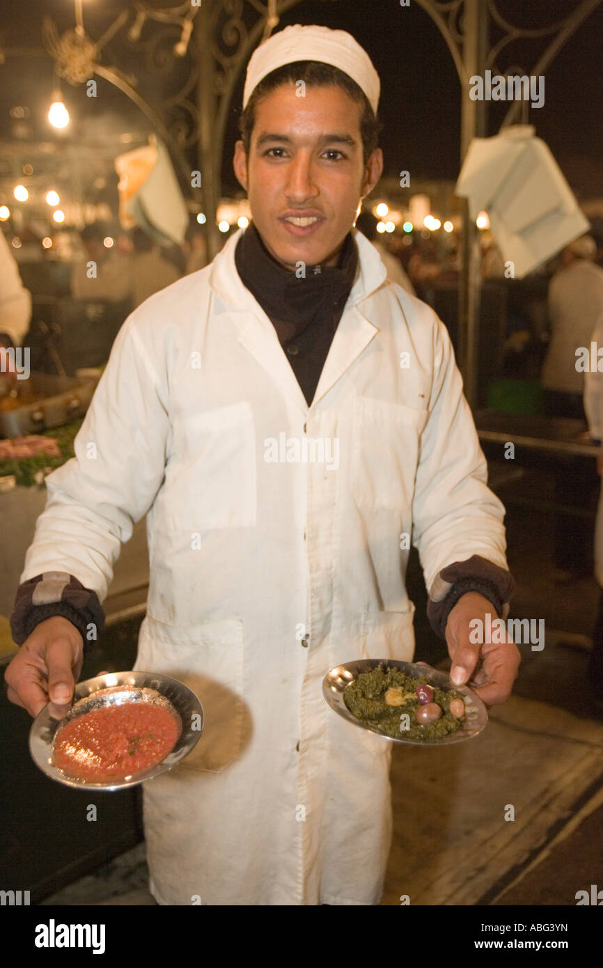 Chef with two plates of sauce evening barbecue food stall Place Djemaa ...