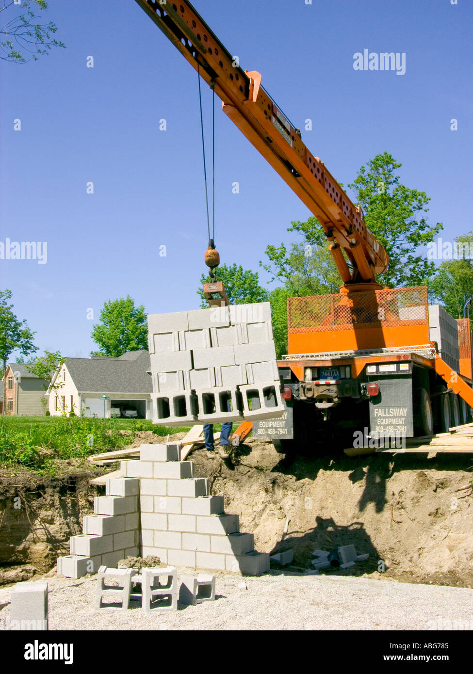 New home construction workers lay cement blocks to form basement of ...