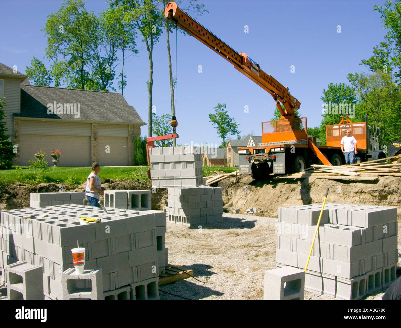 New home construction workers lay cement blocks to form basement of ...