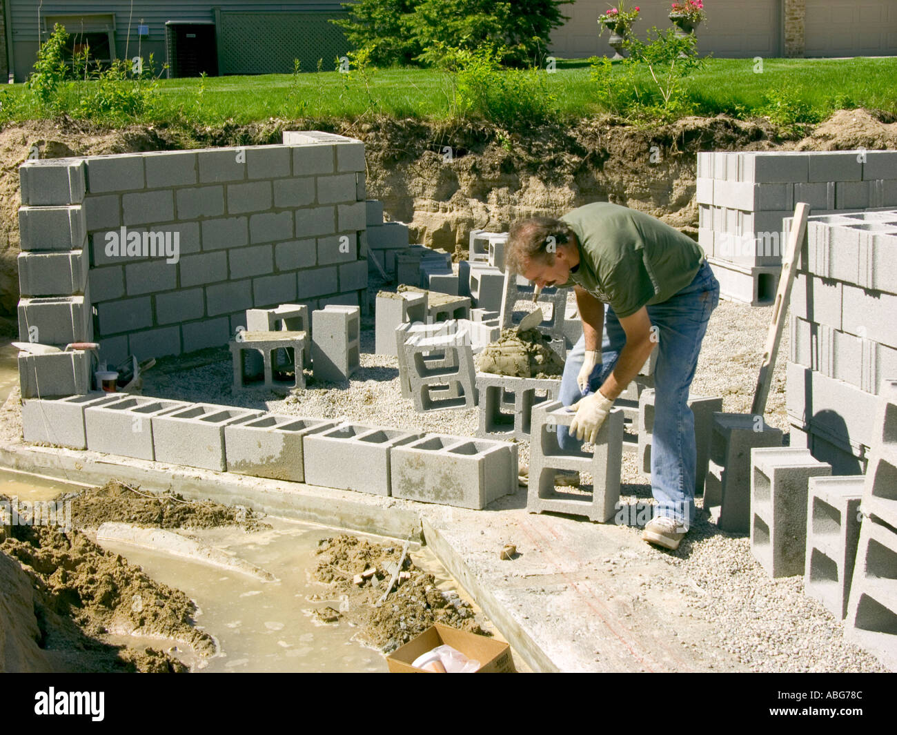 New home construction workers lay cement blocks to form basement of ...